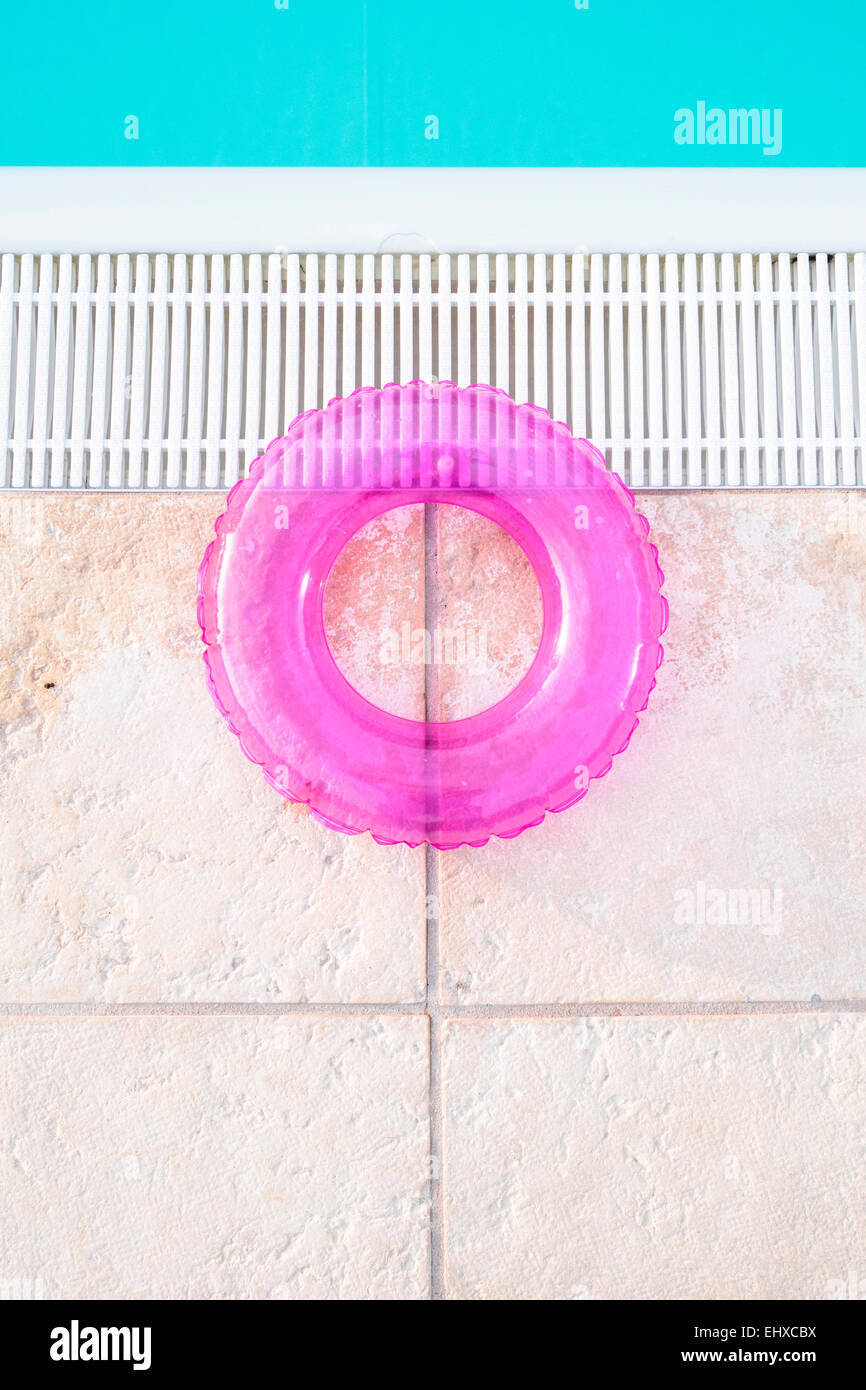 Pink floating tire at pool edge Stock Photo - Alamy
