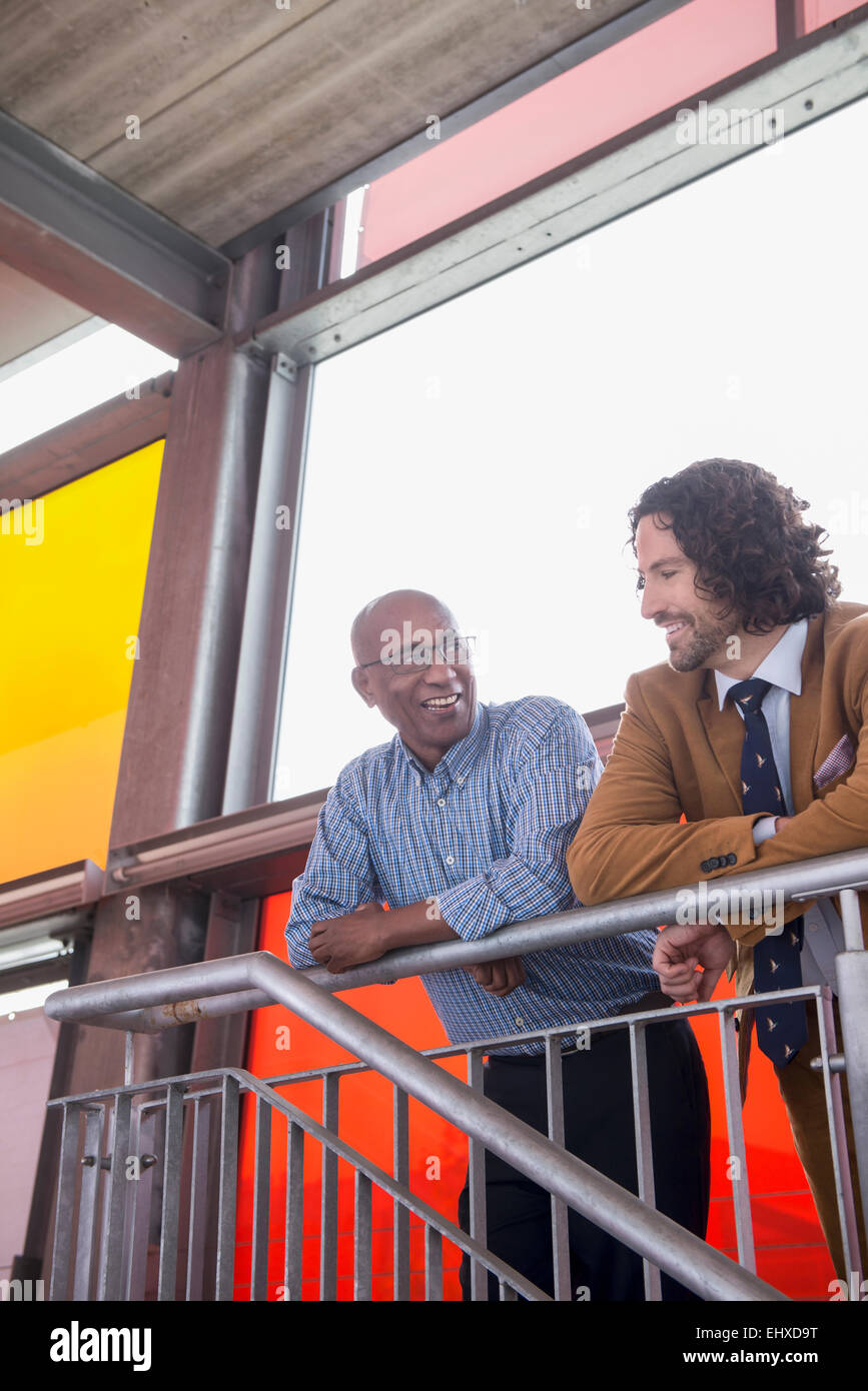 Two men meeting talking African Caucasian railing Stock Photo - Alamy