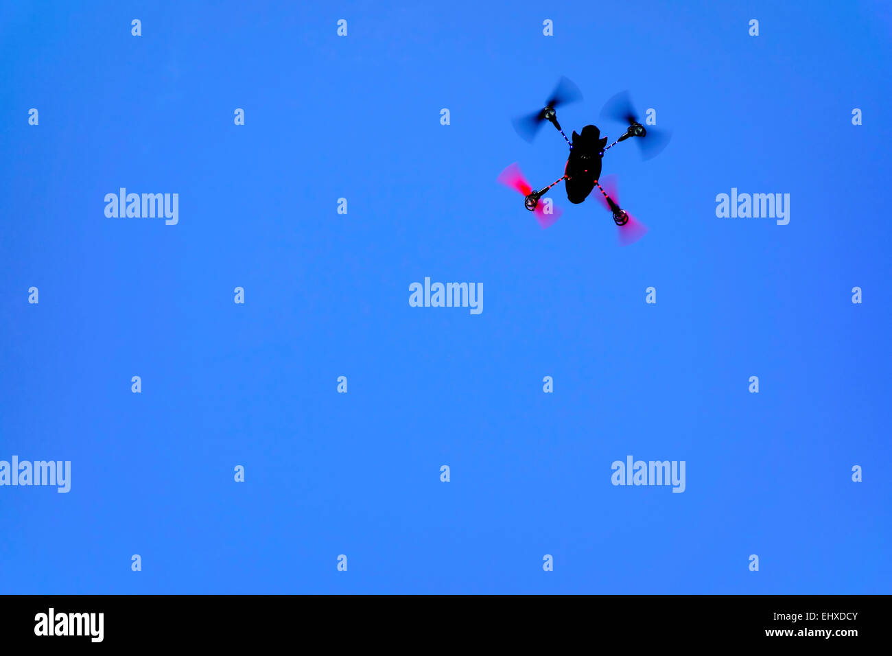 Flying miniature drone in front of blue sky Stock Photo - Alamy