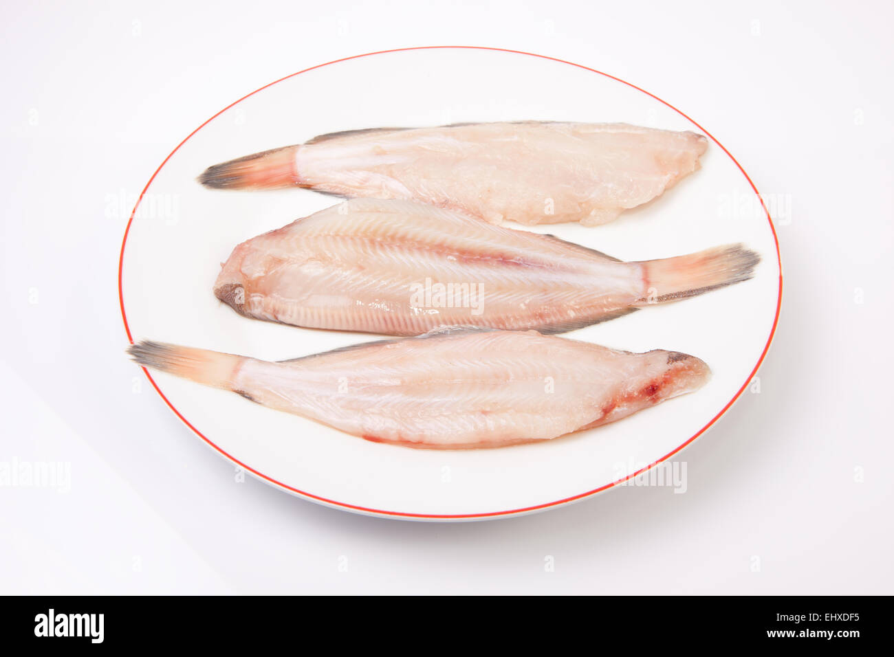 Raw sole fish ready to cook. Plate of three pieces isolated over white ...