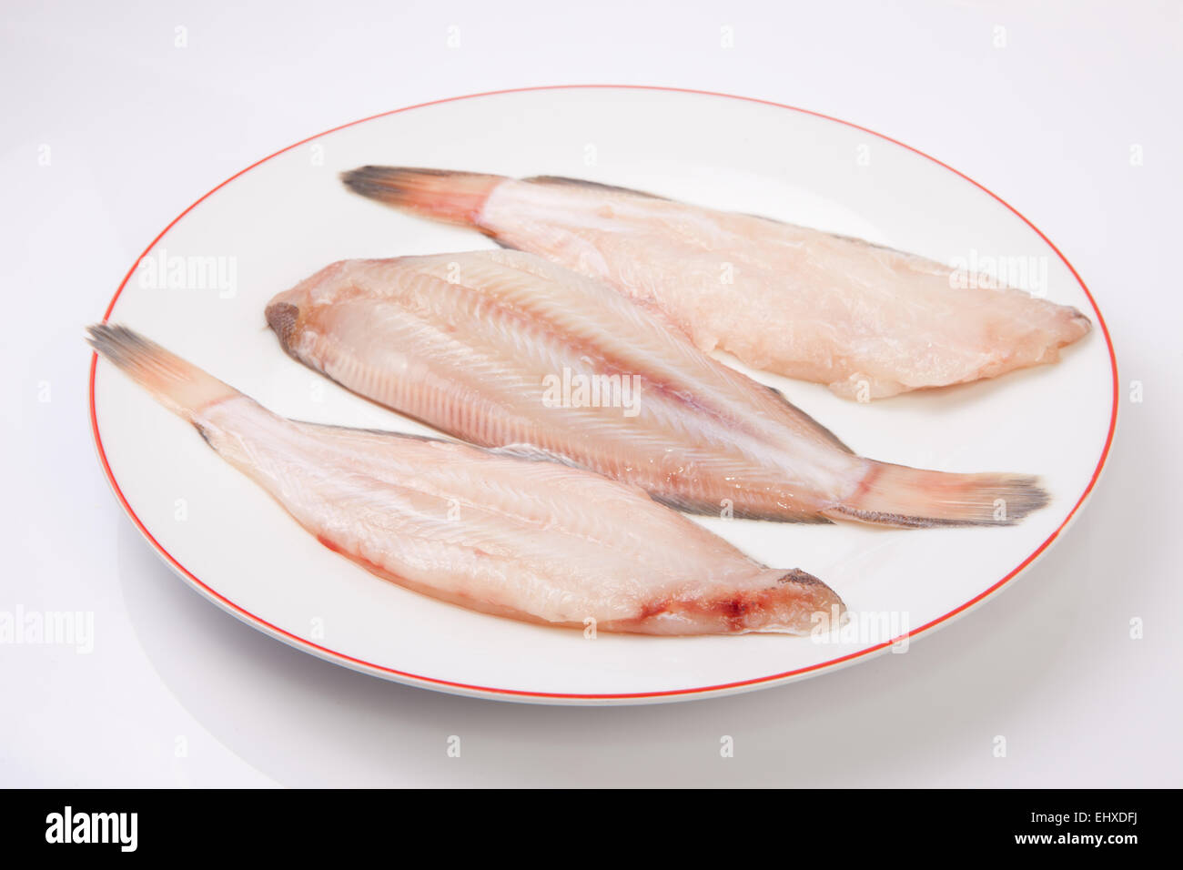 Raw sole fish ready to cook. Plate of three pieces isolated over white ...