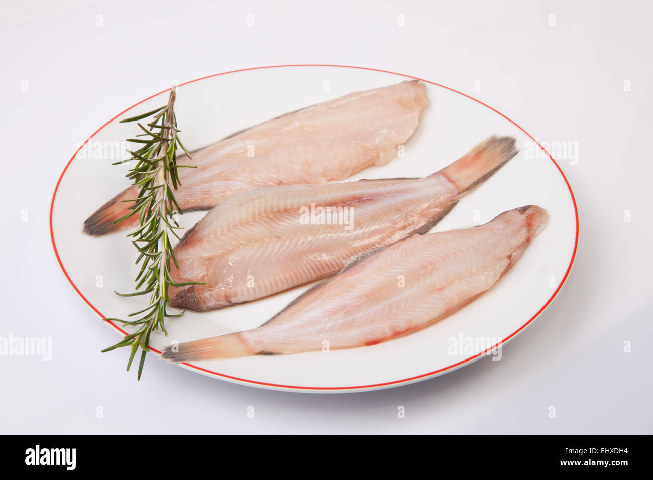 Raw sole fish ready to cook. Plate of three pieces decorated with a ...