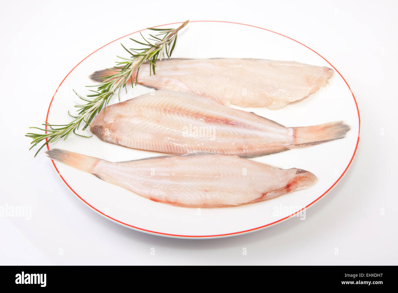 Raw sole fish ready to cook. Plate of three pieces decorated with a ...
