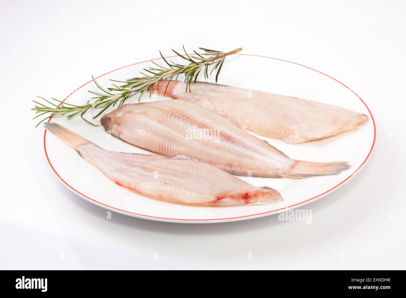 Raw sole fish ready to cook. Plate of three pieces decorated with a ...