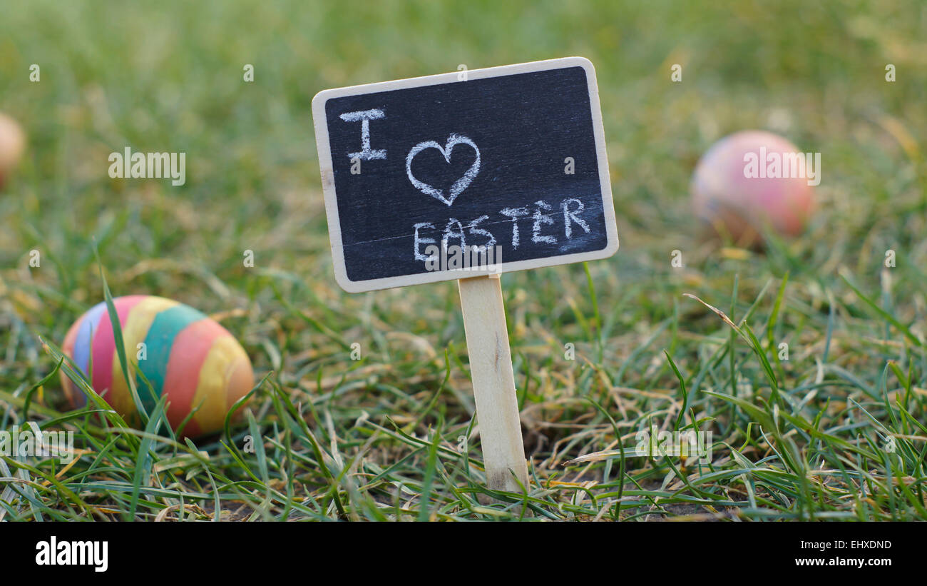 I love easter written on a chalkboard standing in grass between easter ...