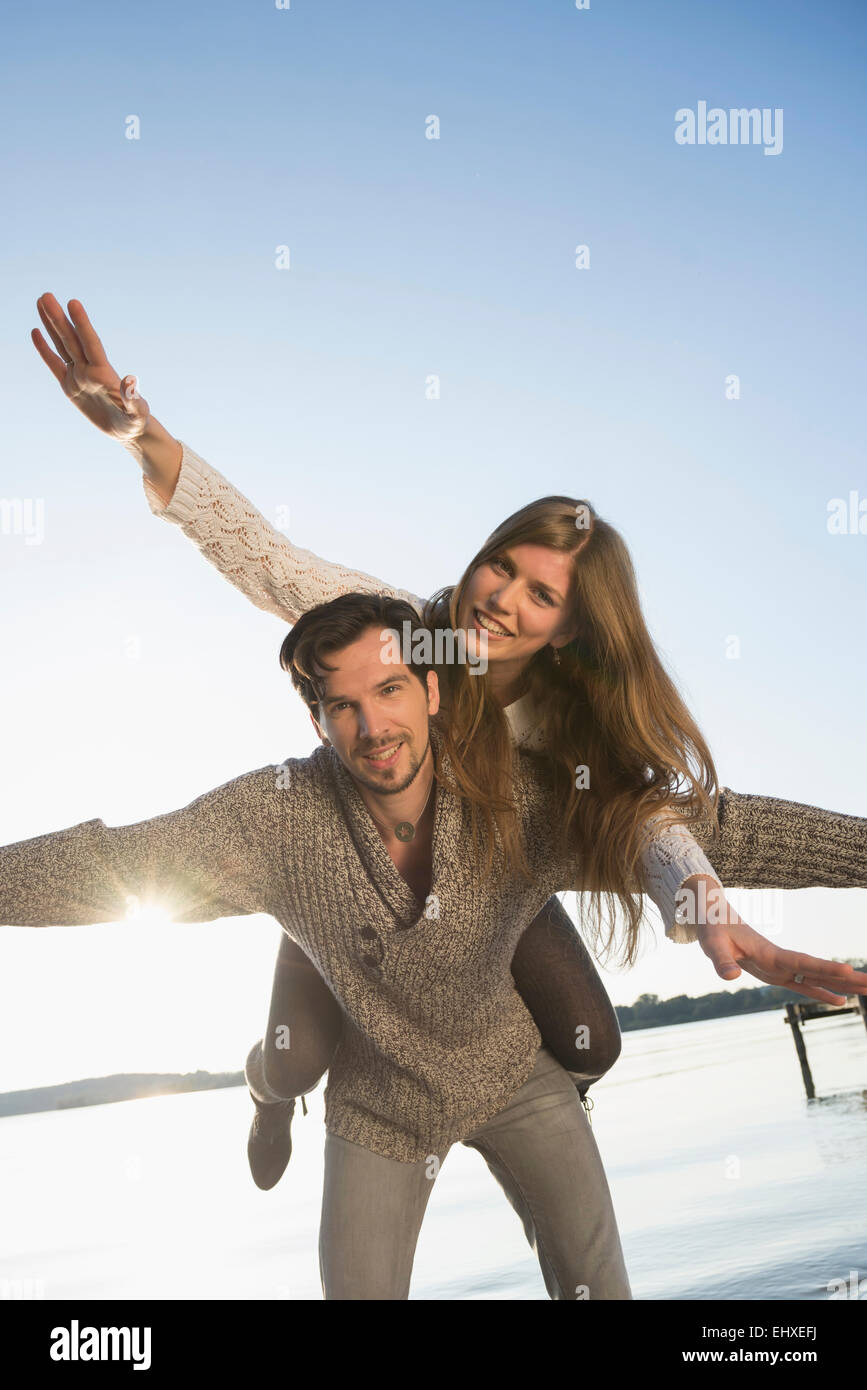 Young happy couple fun dancing piggyback sunset Stock Photo - Alamy
