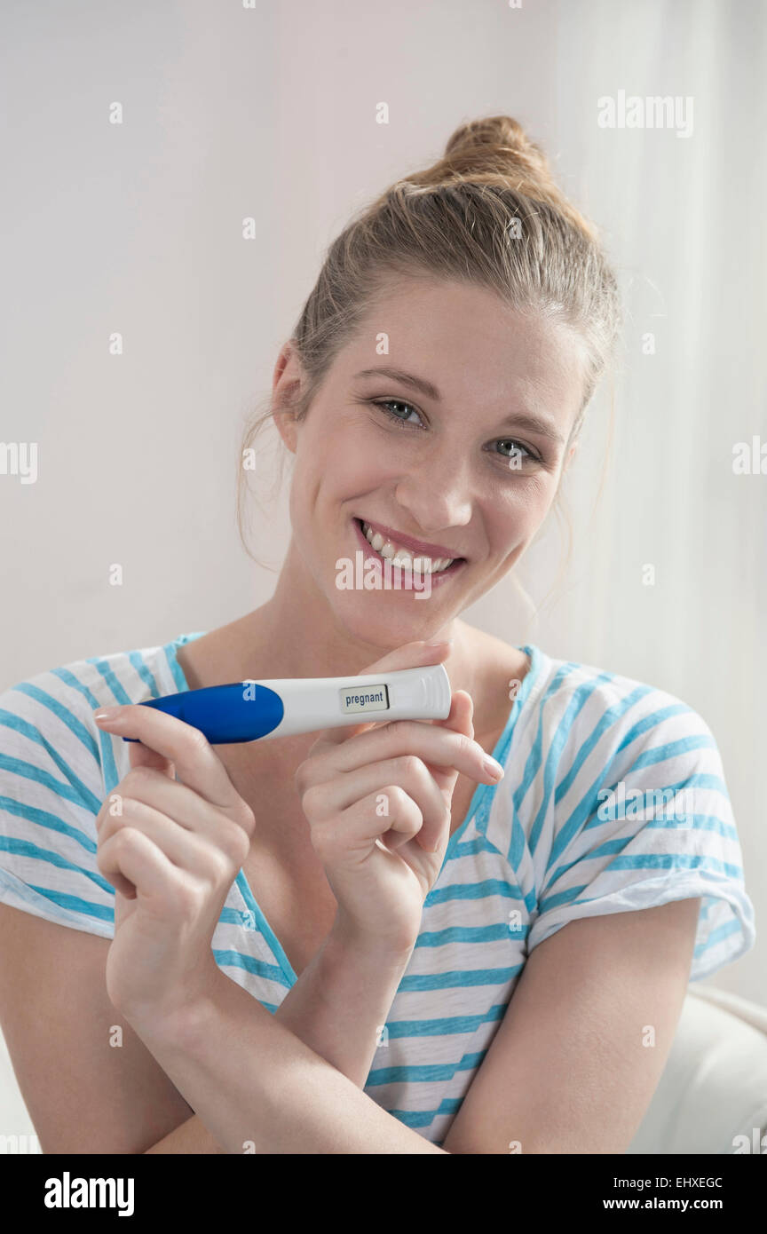 Portrait young woman holding pregnancy test Stock Photo - Alamy