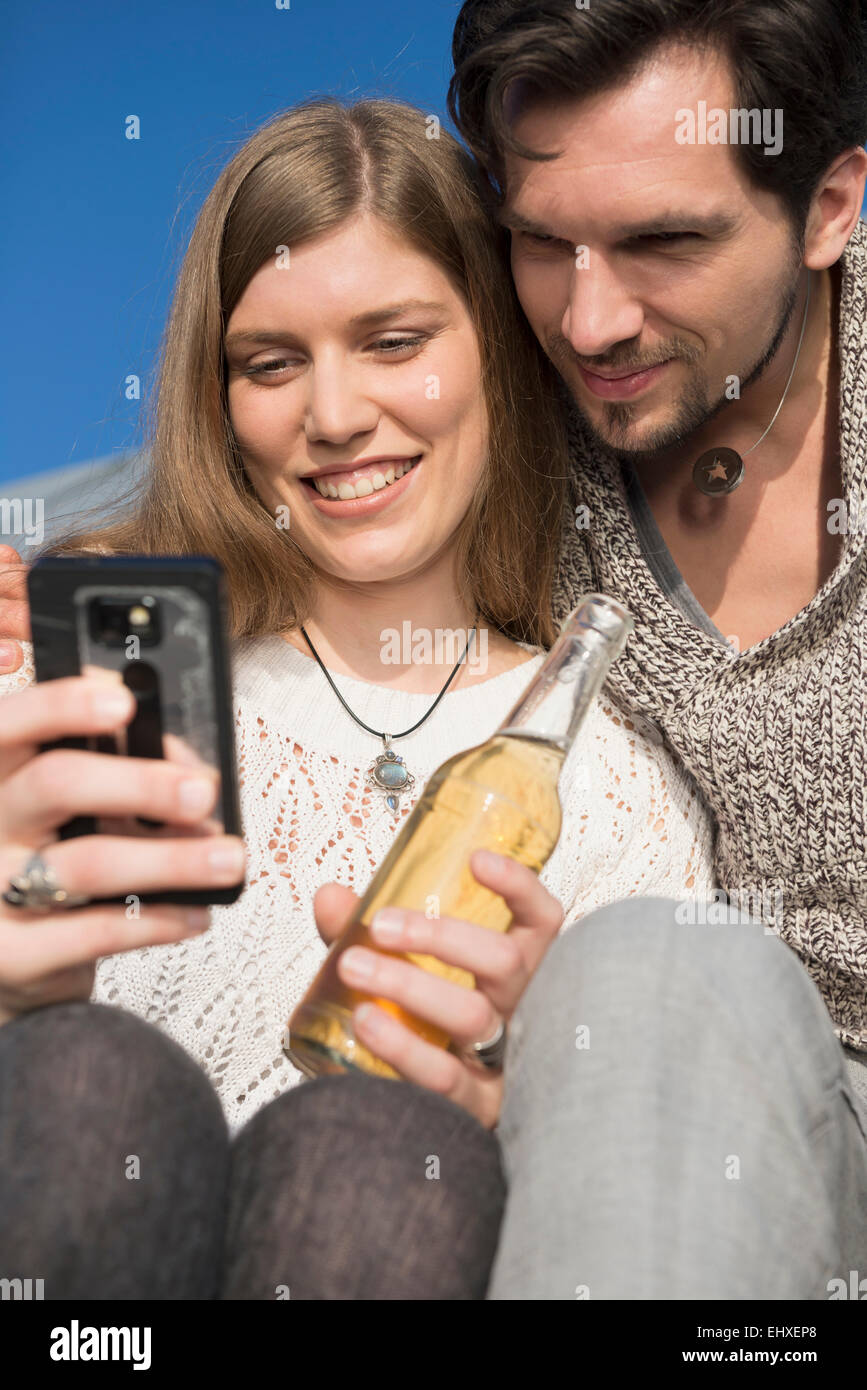 Portrait young couple cell phone SMS beer Stock Photo - Alamy