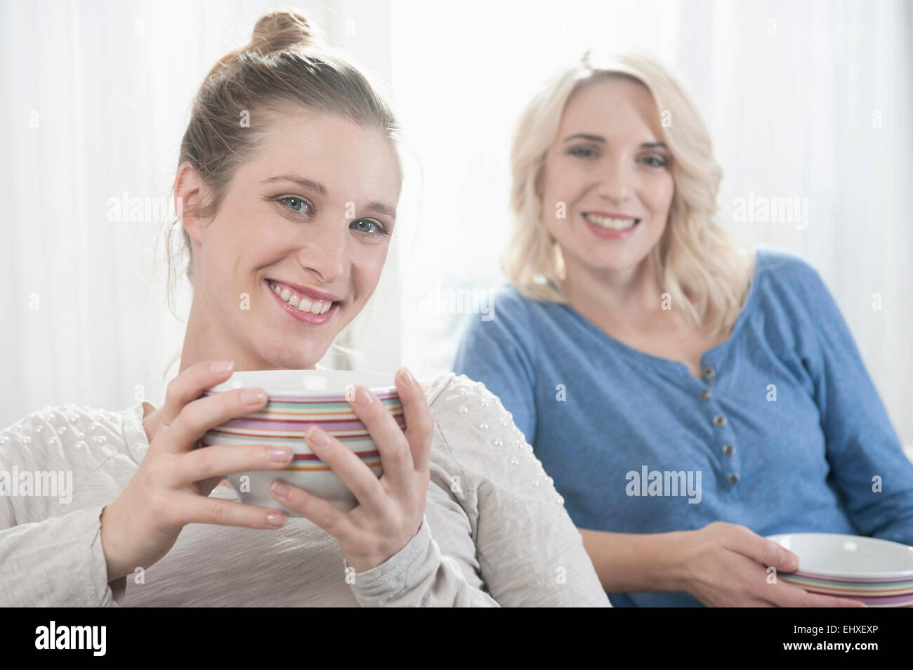 Portrait two women tee drinking smiling girlfriend Stock Photo - Alamy