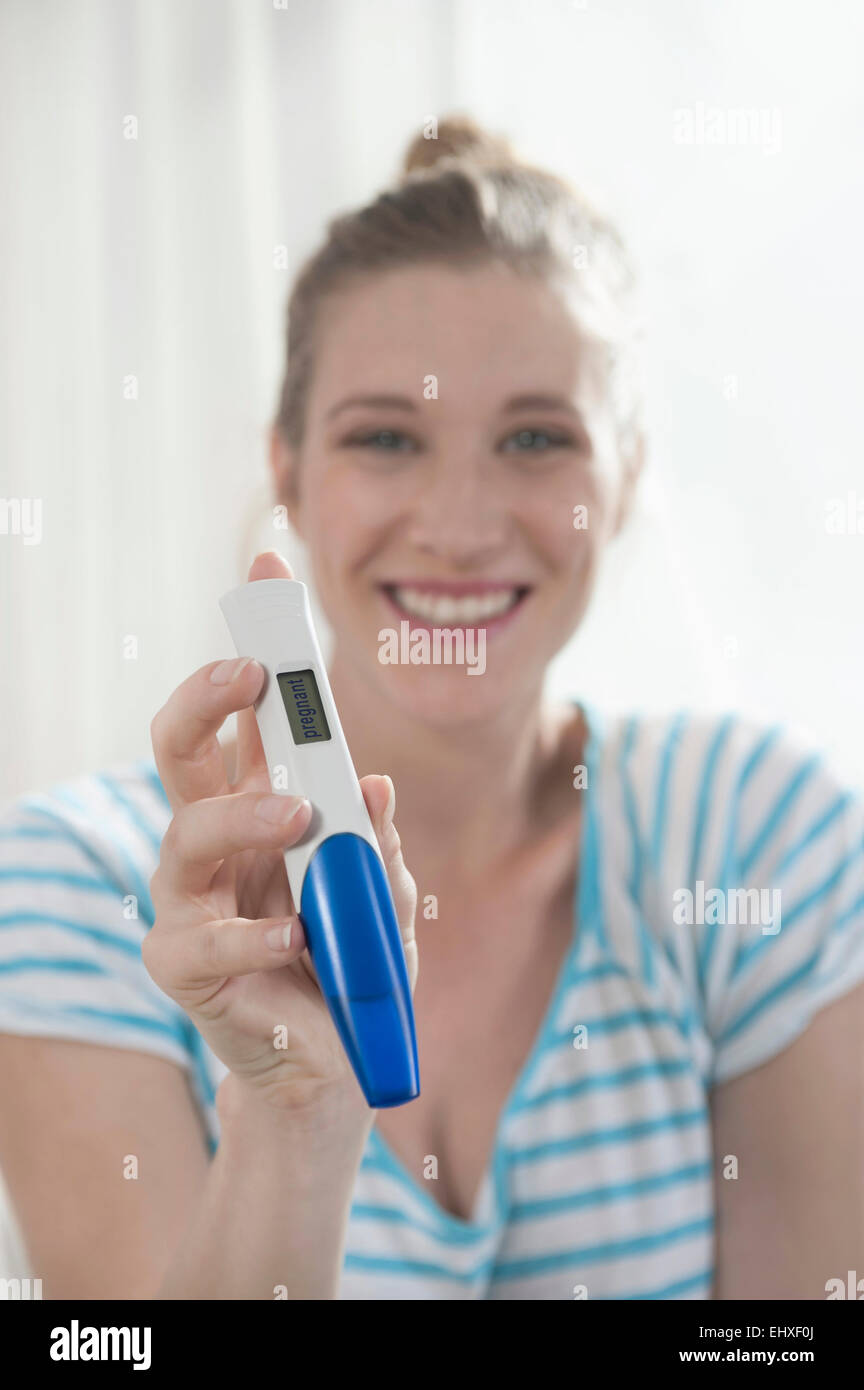 Happy young woman holding pregnancy test Stock Photo - Alamy