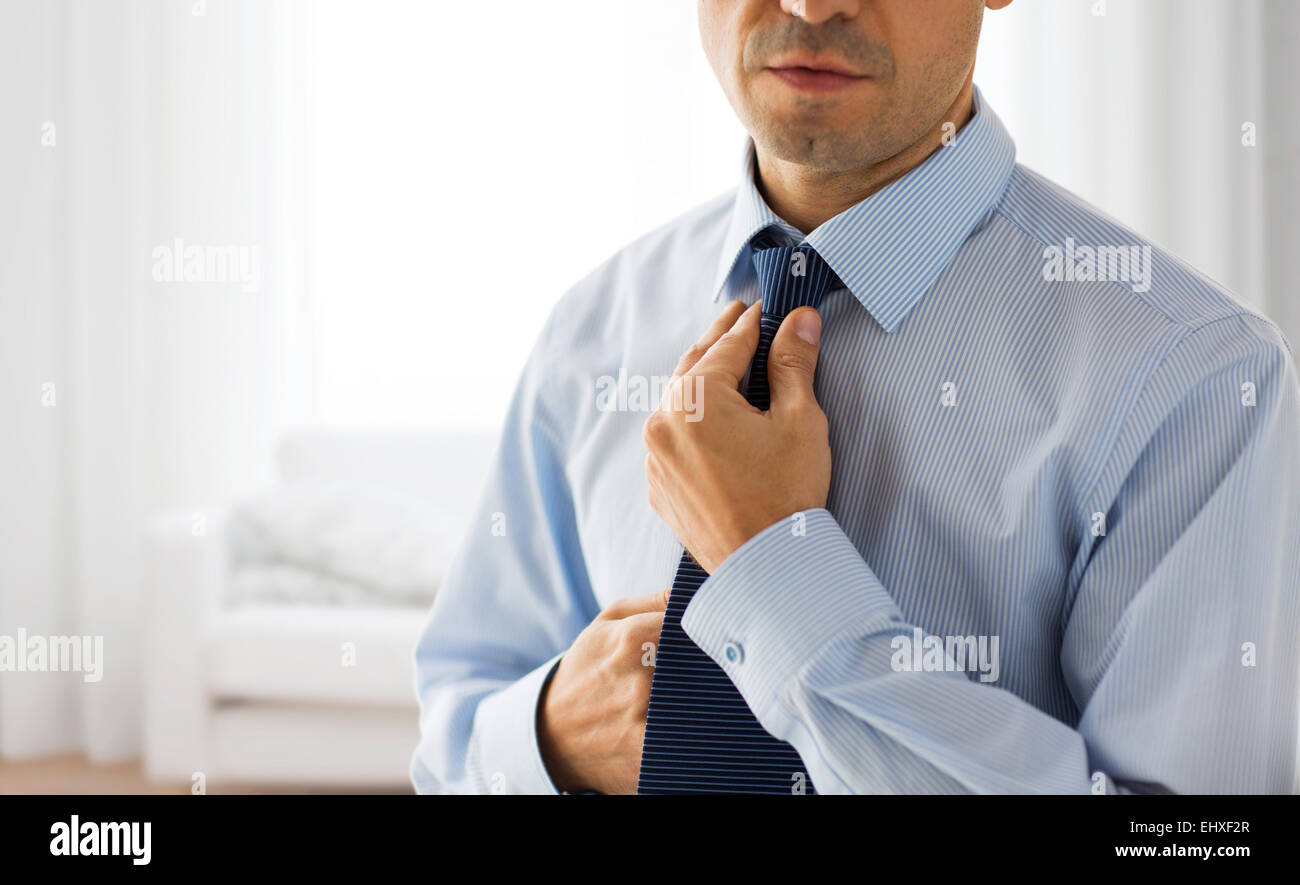 close up of man in shirt adjusting tie on neck Stock Photo - Alamy