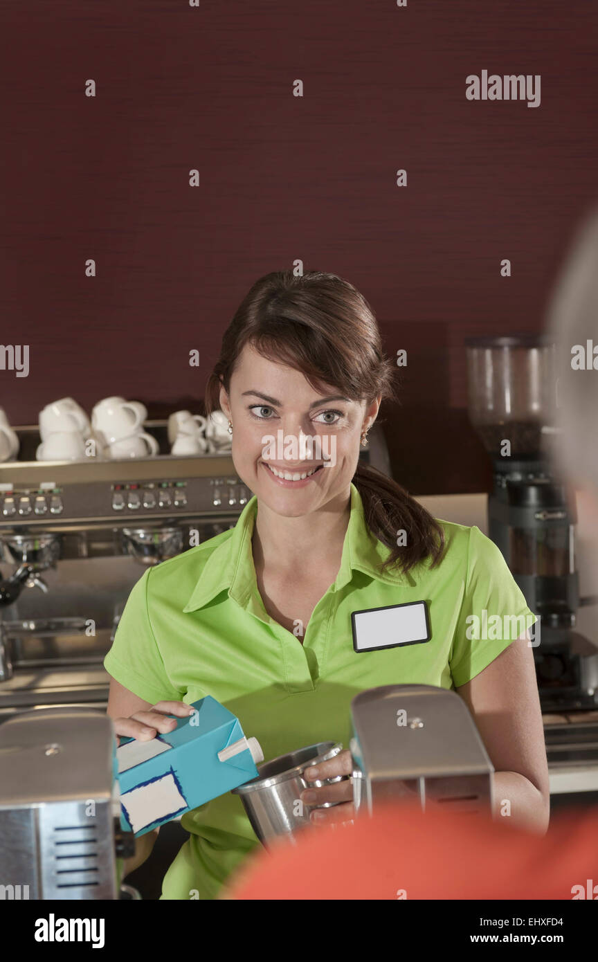 Young waitress smiling fitness studio counter Stock Photo - Alamy