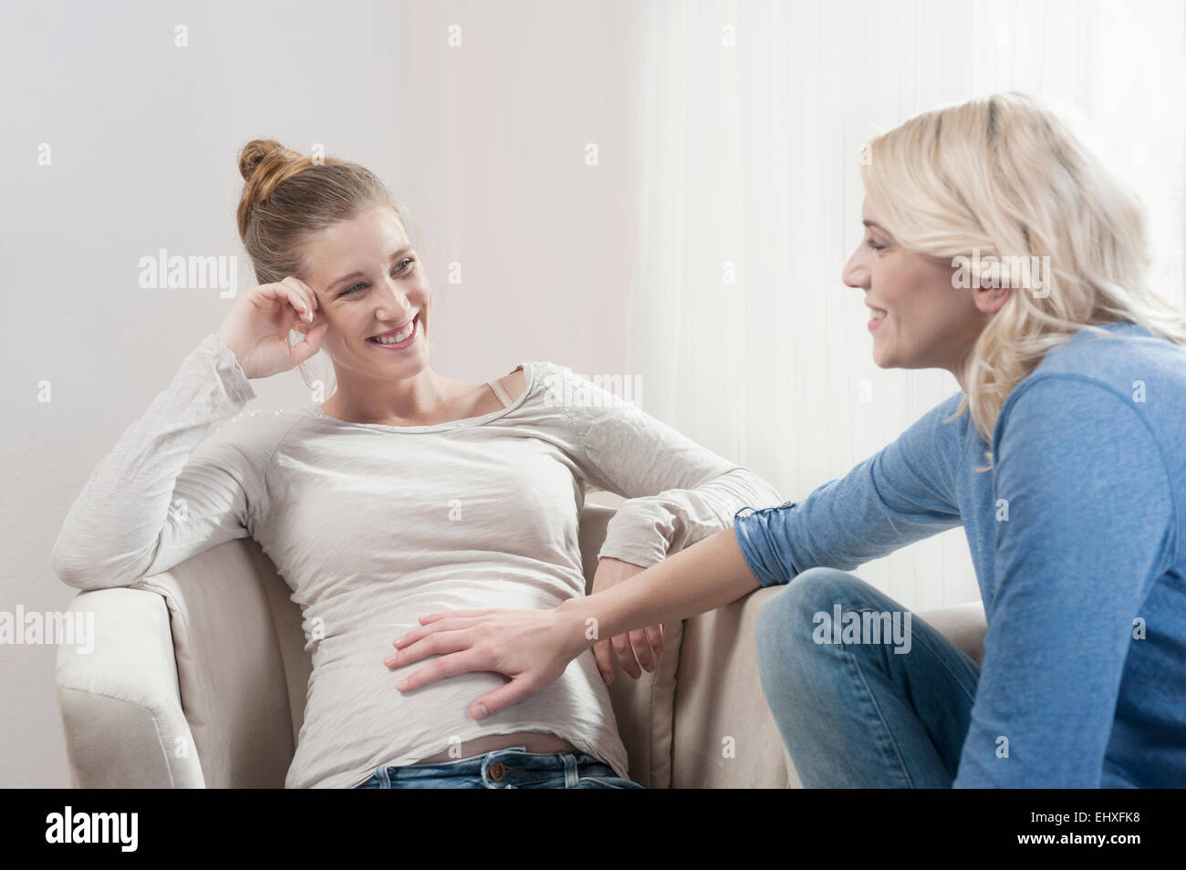Pregnant woman girlfriend talking touching stomach Stock Photo - Alamy