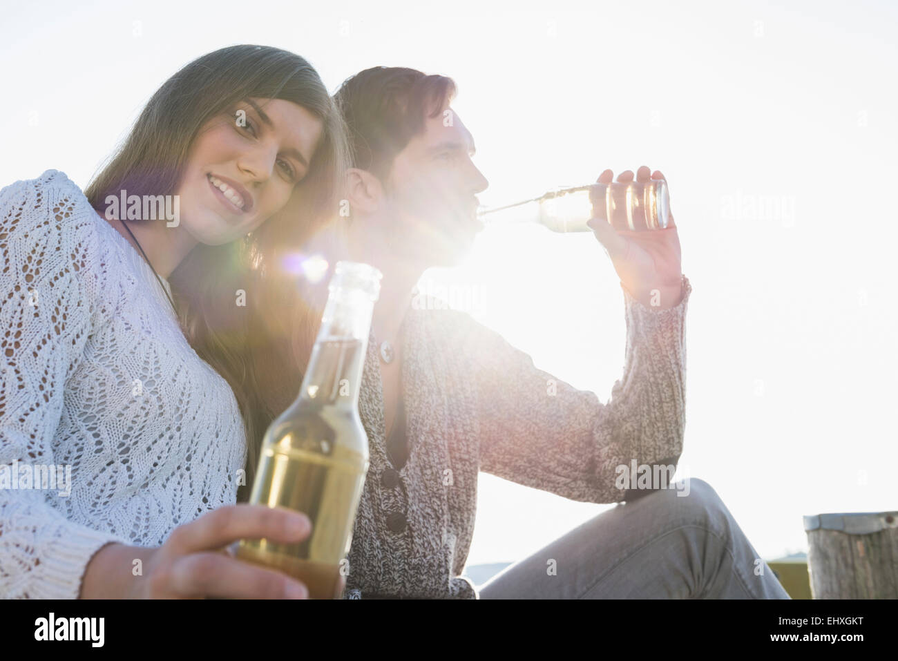 Young man woman drinking beer sunset Stock Photo - Alamy