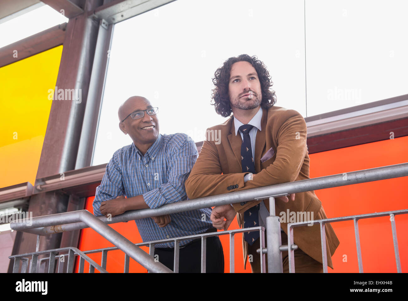 Two men meeting talking African Caucasian railing Stock Photo - Alamy