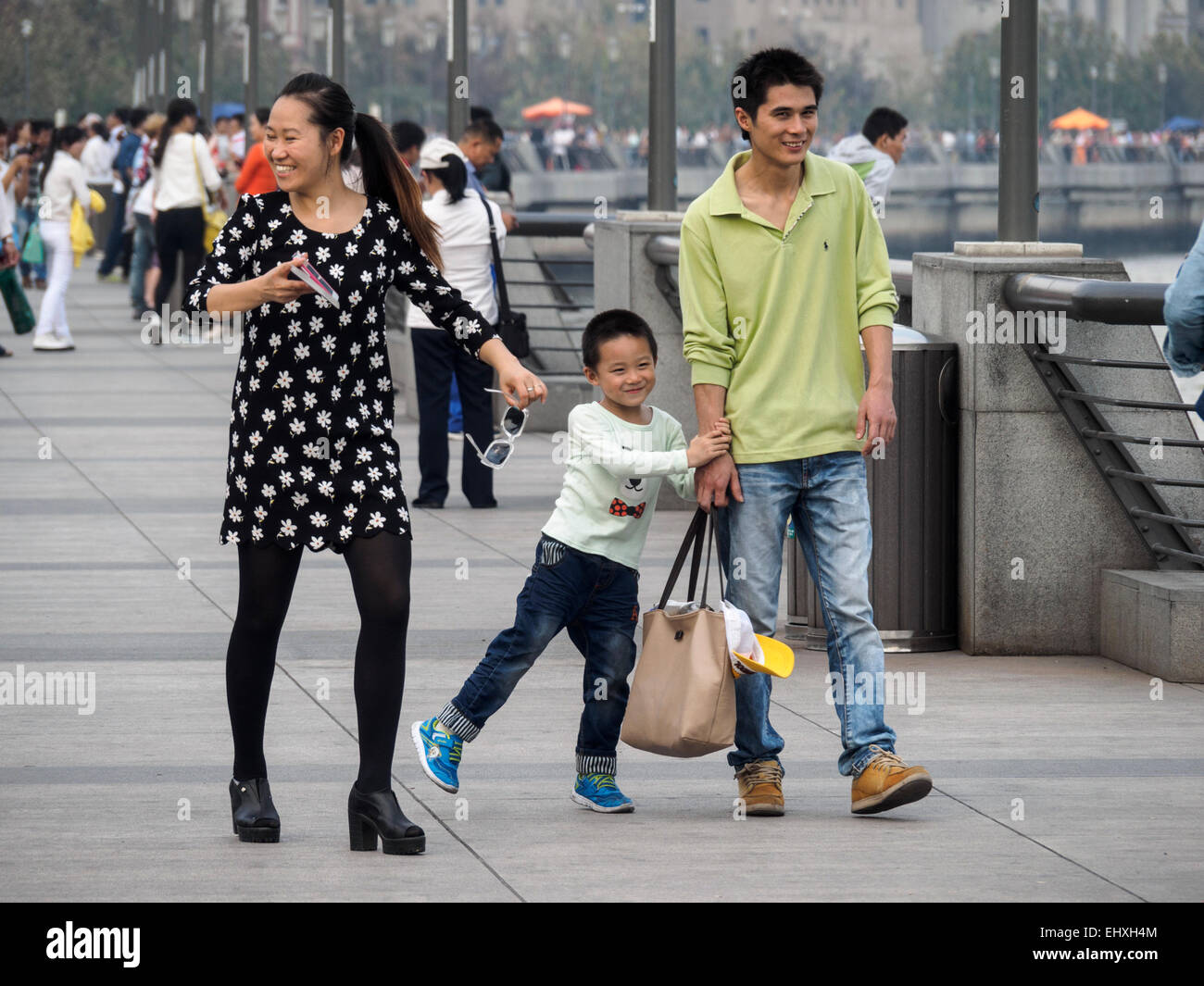 Chinese family - young parents holding hands with single child Stock ...