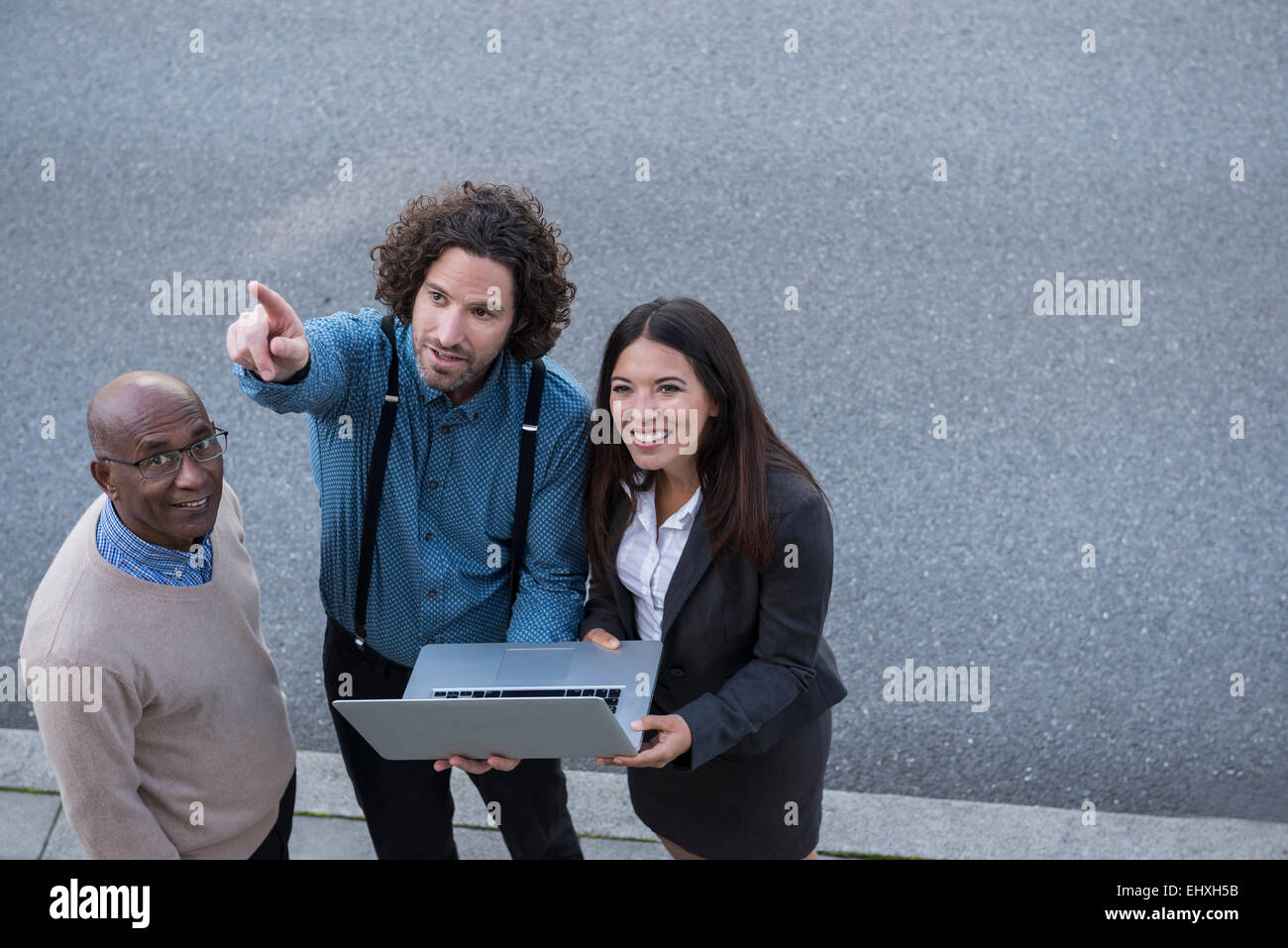 Man pointing explaining laptop work colleagues Stock Photo - Alamy