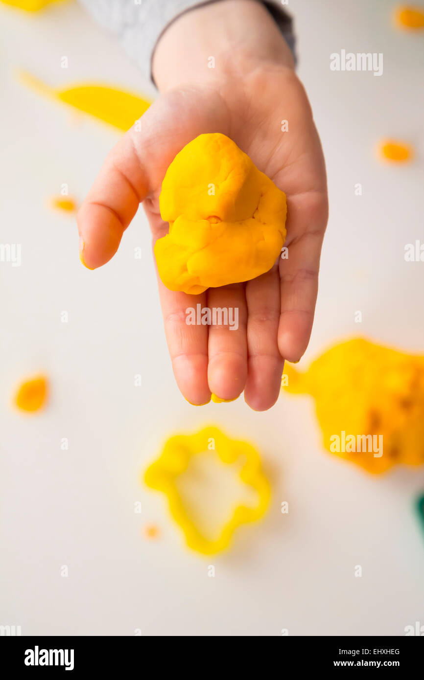 Girl's hand holding modeling clay Stock Photo - Alamy