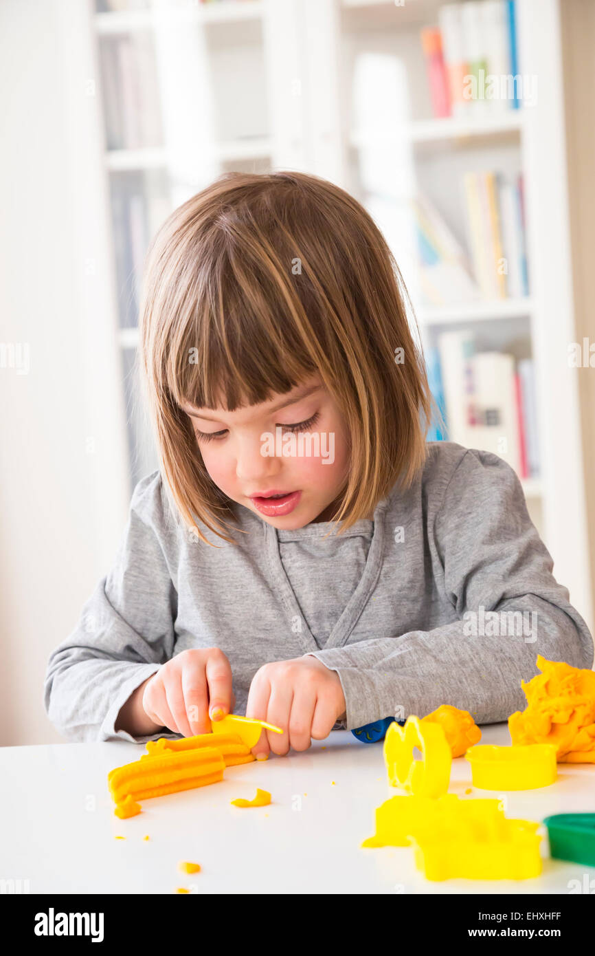 Little girl playing yellow modeling hi-res stock photography and images ...