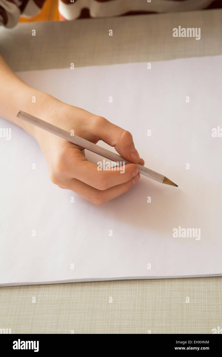 Boy's hand holding pencil Stock Photo - Alamy