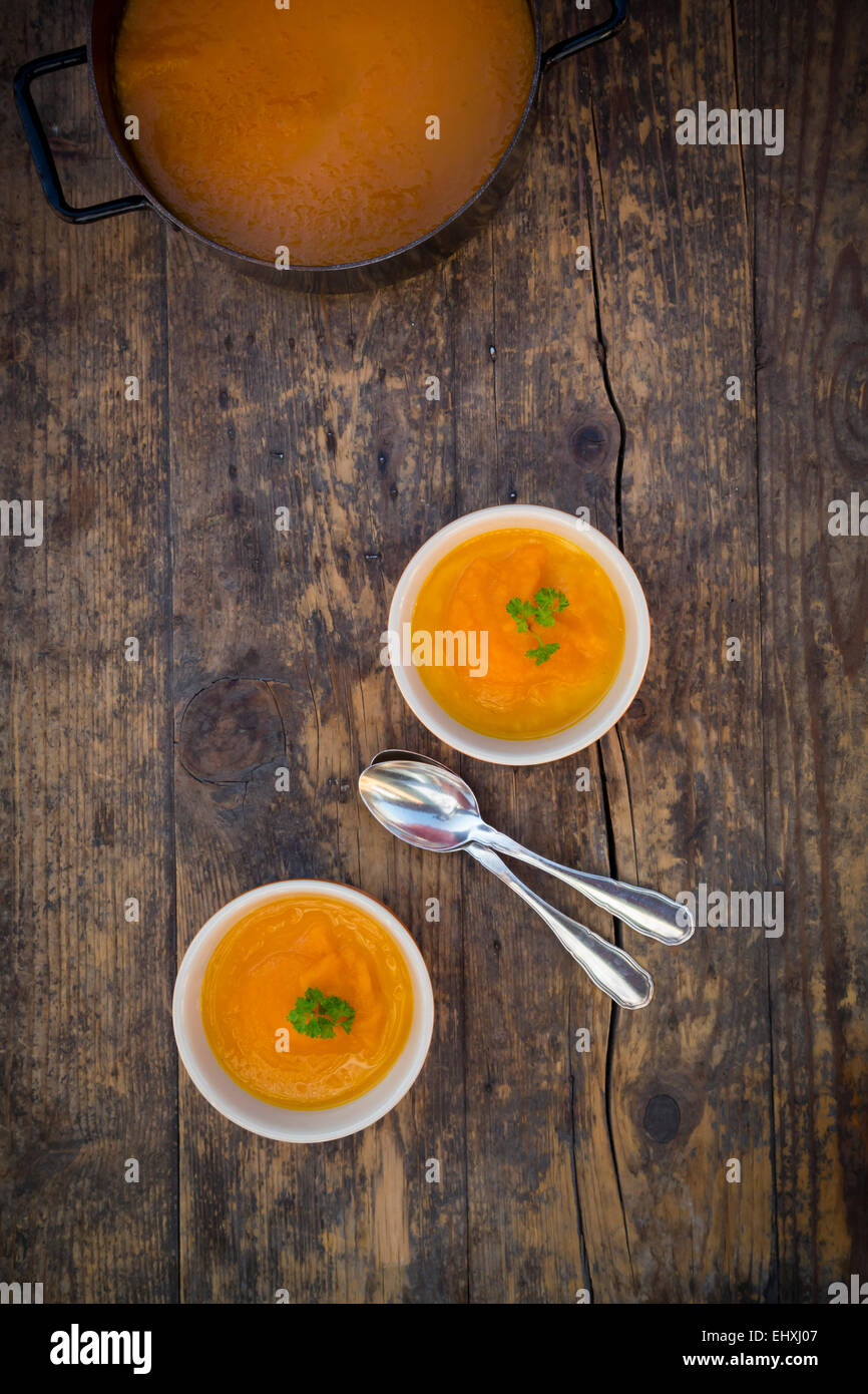 Cooking pot and bowls of carrot soup Stock Photo - Alamy