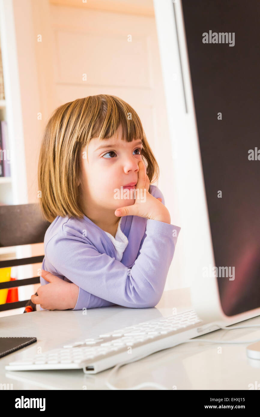 Portrait of little girl spending time at computer Stock Photo - Alamy