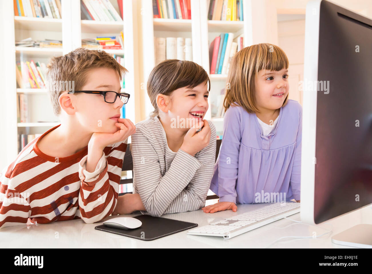 Boy and his two sisters spending time at computer Stock Photo - Alamy