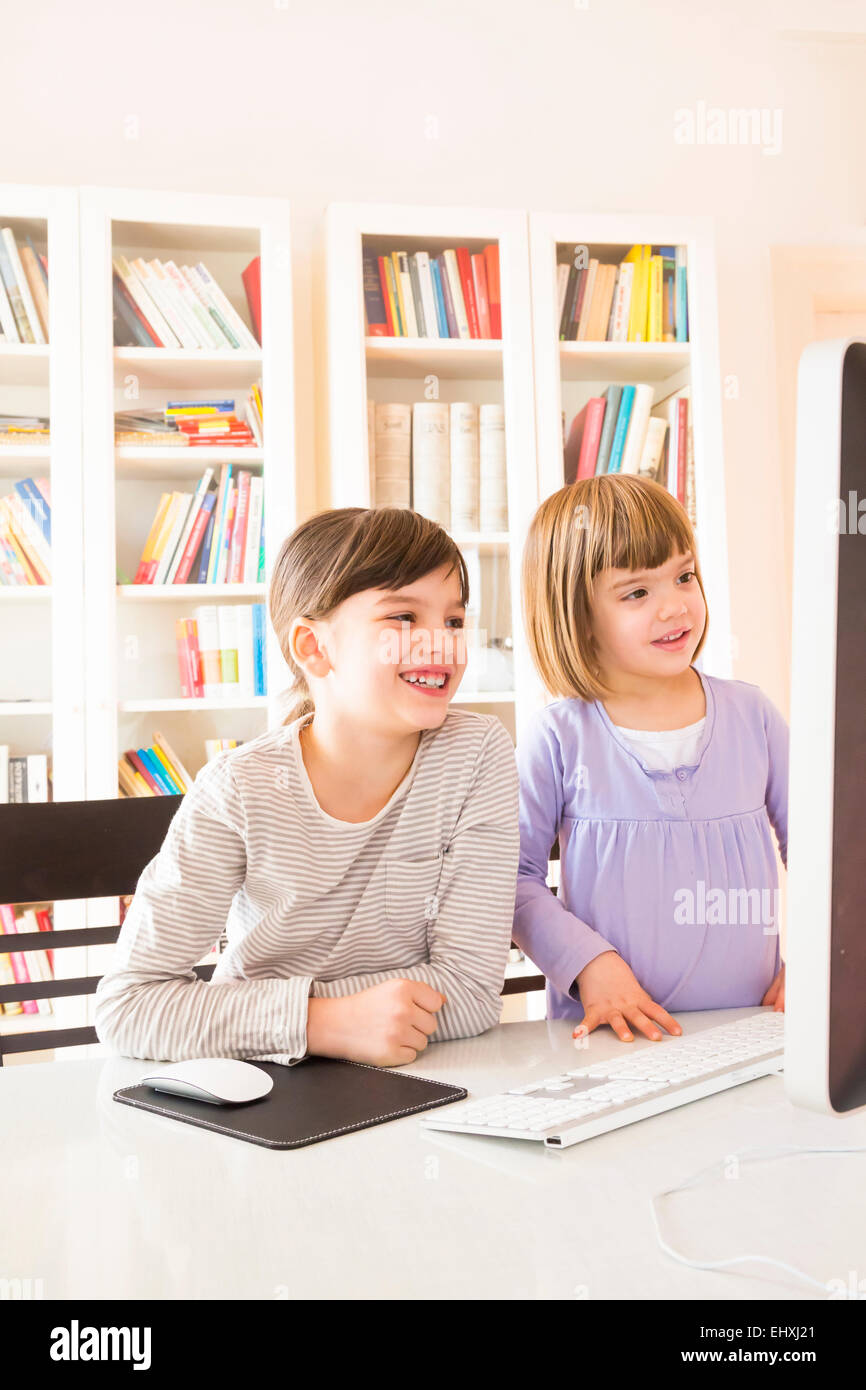 Two sisters spending time together at computer Stock Photo - Alamy