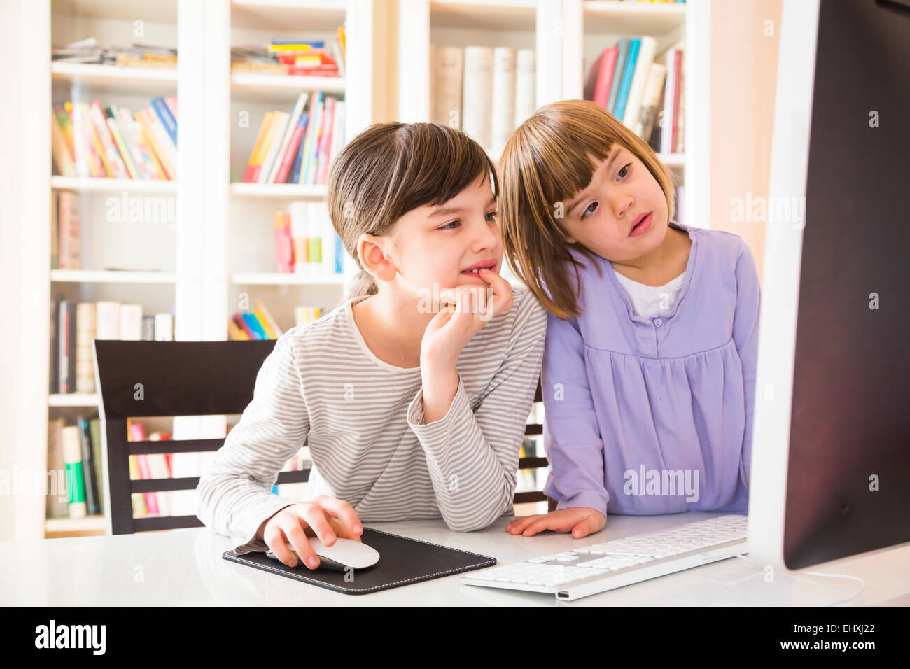 Two sisters spending time together at computer Stock Photo - Alamy