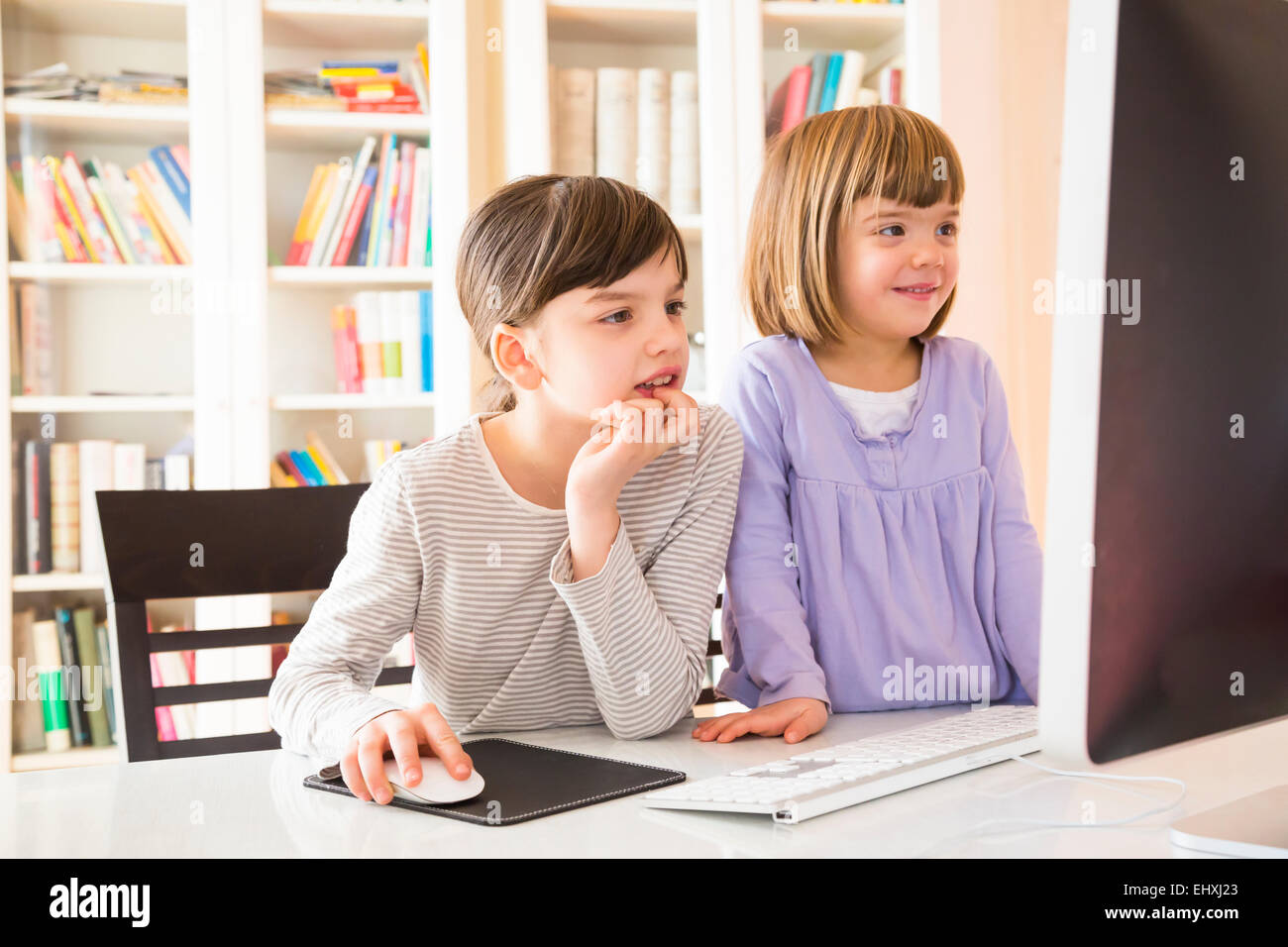 Two sisters spending time together at computer Stock Photo - Alamy
