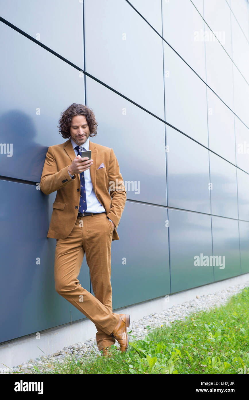Portrait man business suit cell phone reading SMS Stock Photo - Alamy