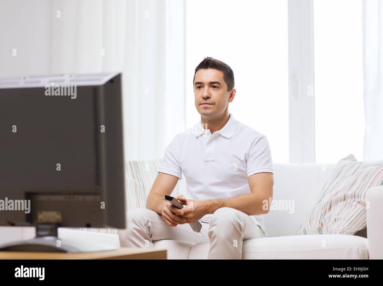 man with remote control watching tv Stock Photo - Alamy