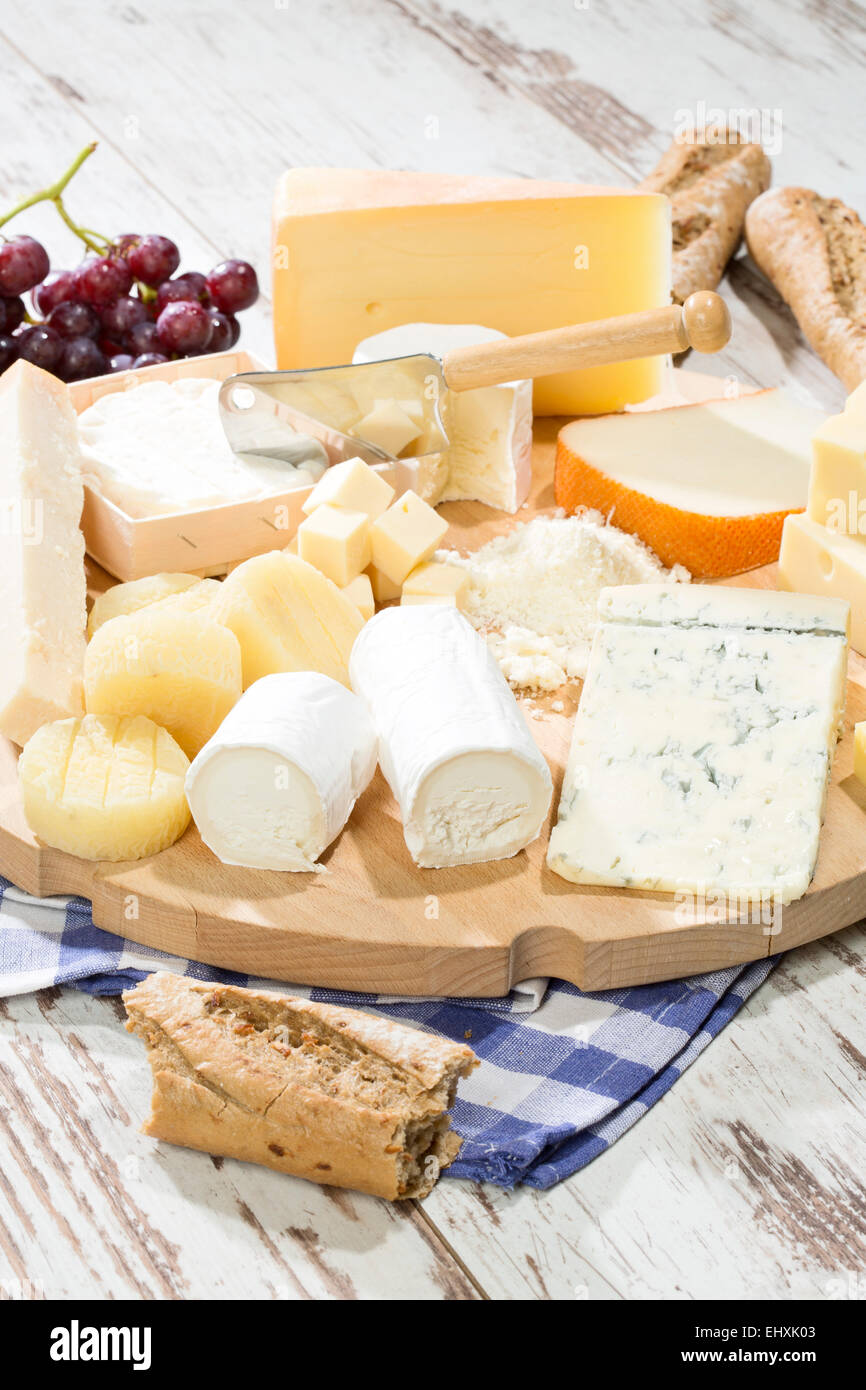 Cheese platter with different sorts of cheese, baguette and grapes on ...