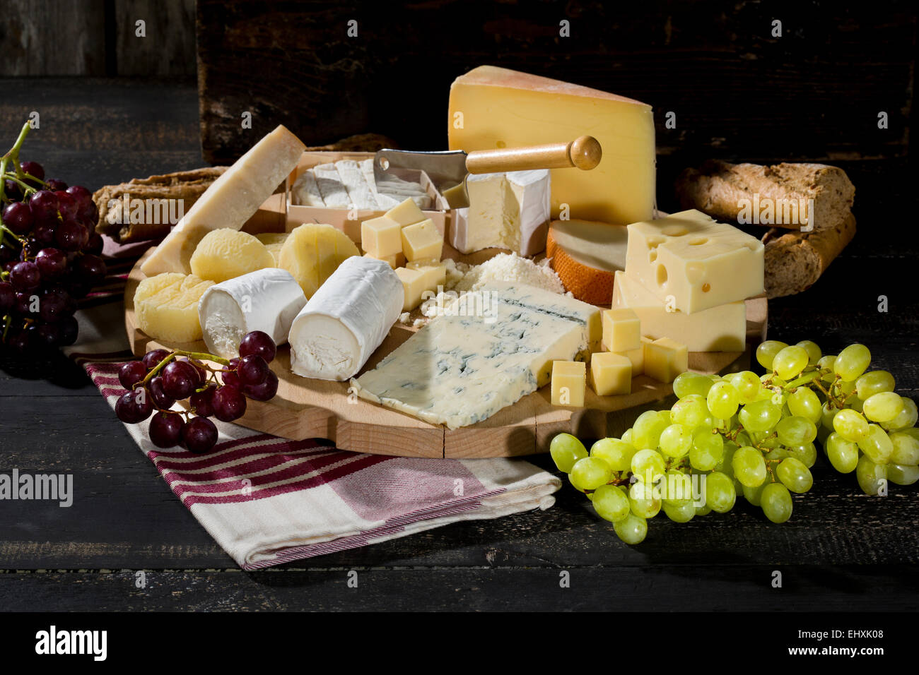 Cheese platter with different sorts of cheese, baguette and grapes on ...