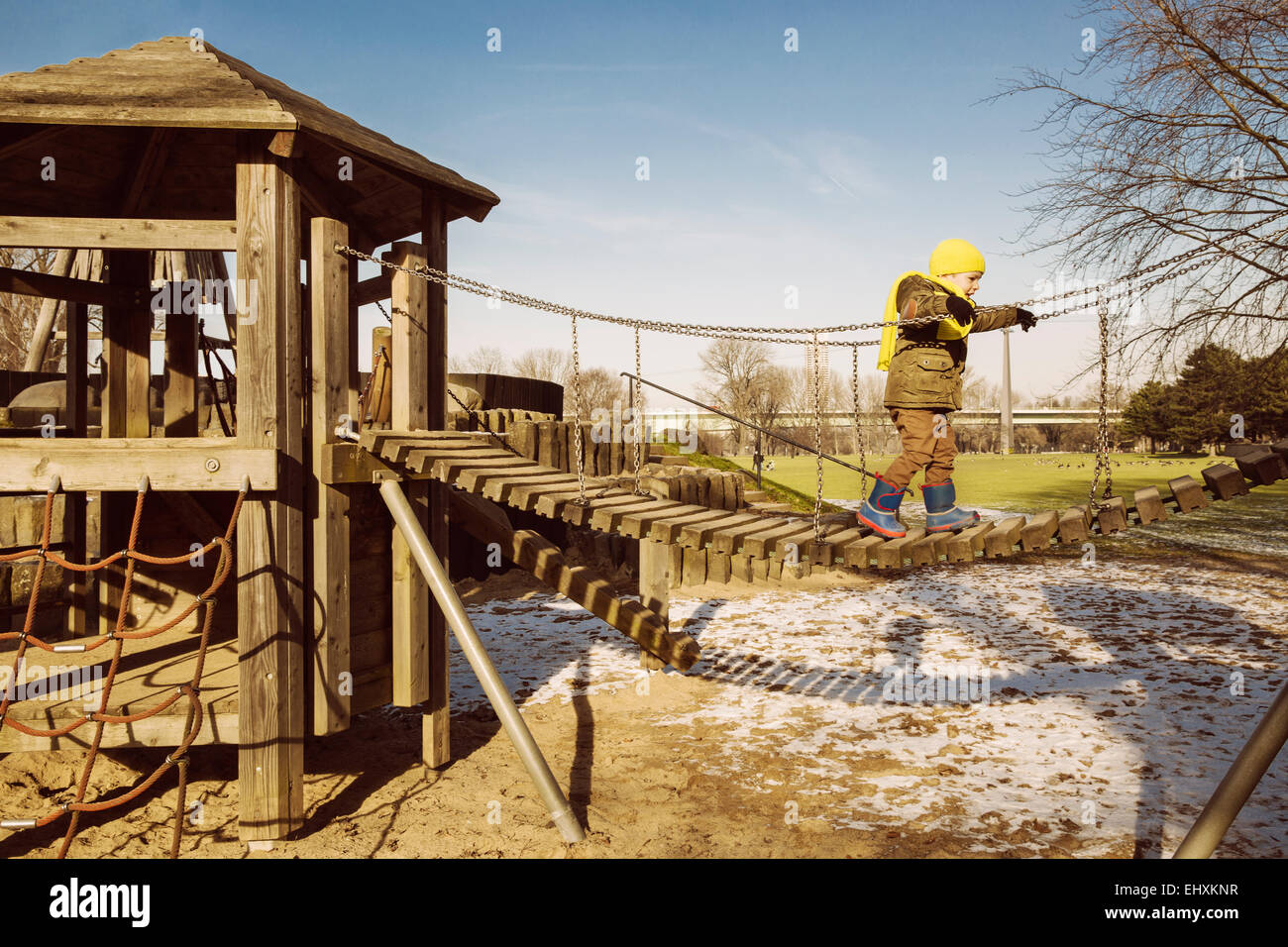Little boy walking along a hanging bridge on a playground Stock Photo ...