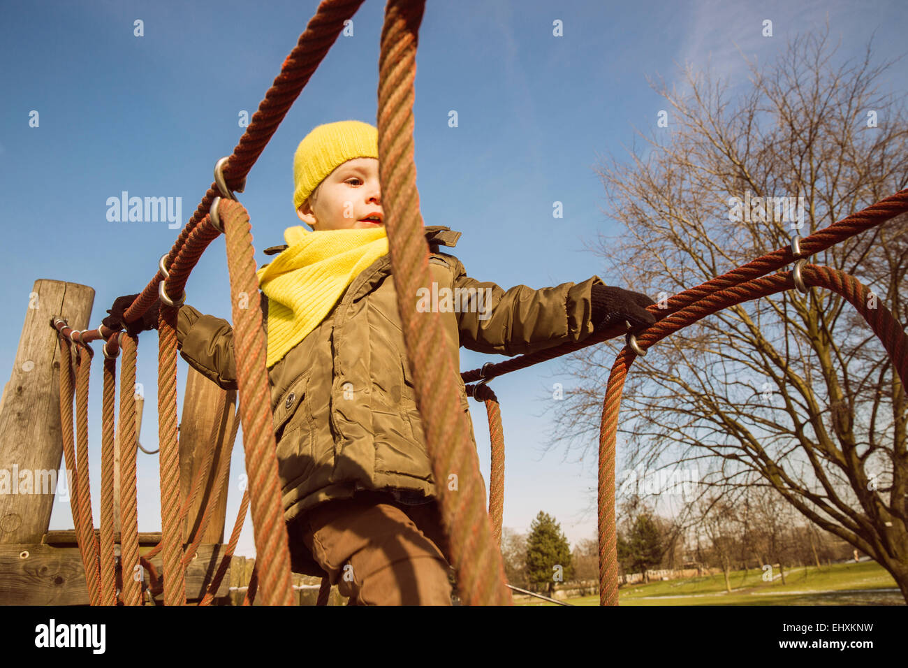 Little boy walking along a hanging bridge on a playground Stock Photo ...
