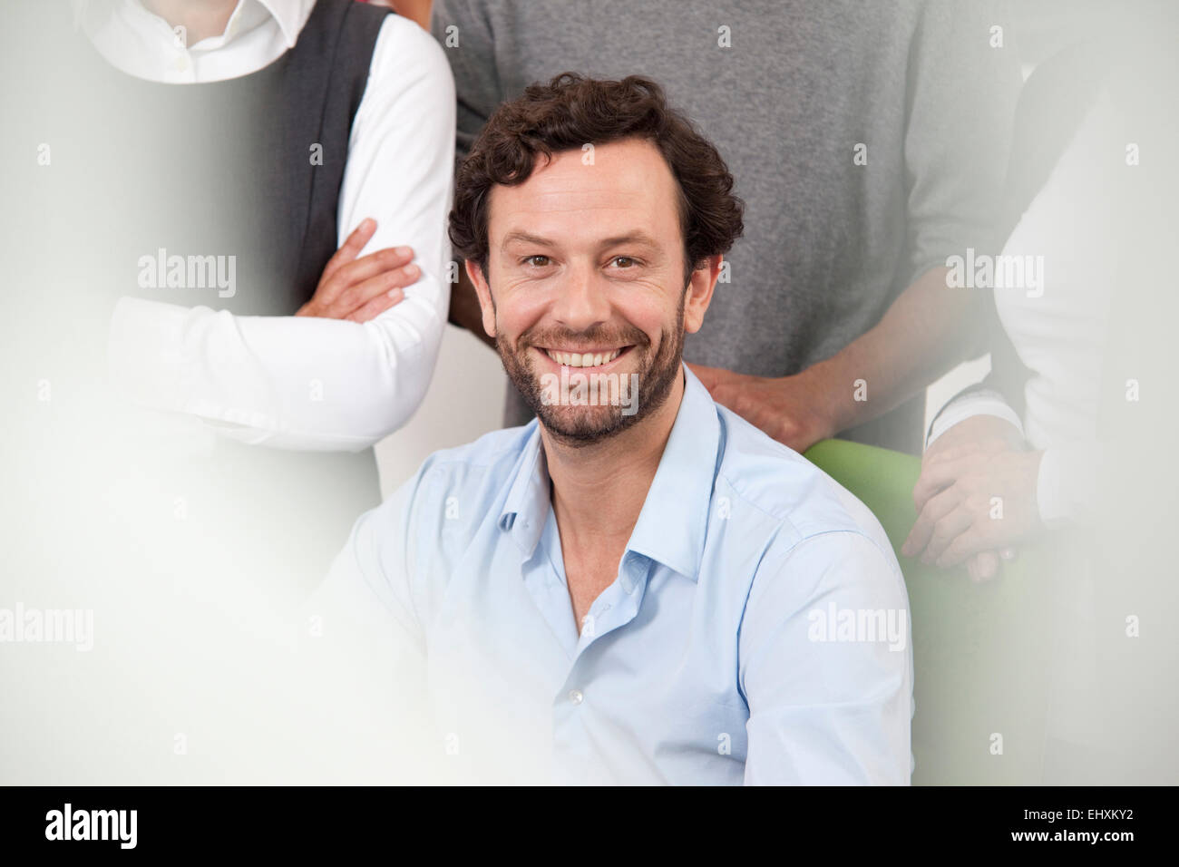 Smiling businessman amongst staff Stock Photo - Alamy