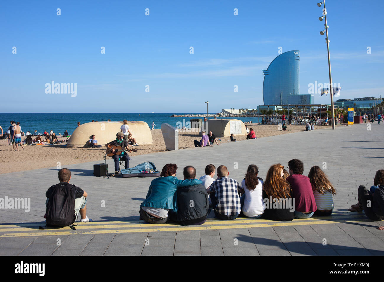 People on Barceloneta promenade listen to a busker in Barcelona, Catalonia, Spain Stock Photo ...
