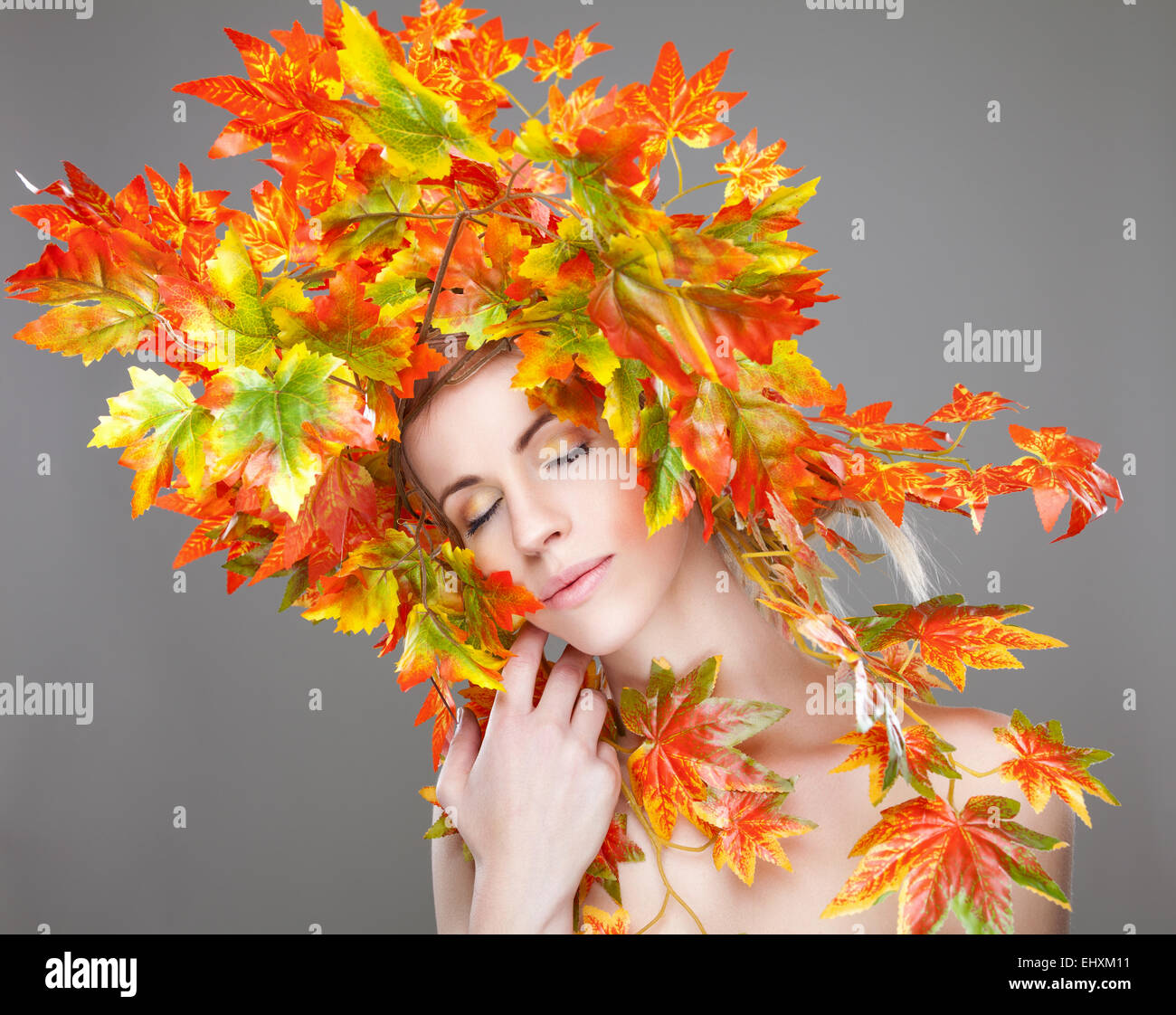 Woman wrapped up in autumn leaves Stock Photo - Alamy