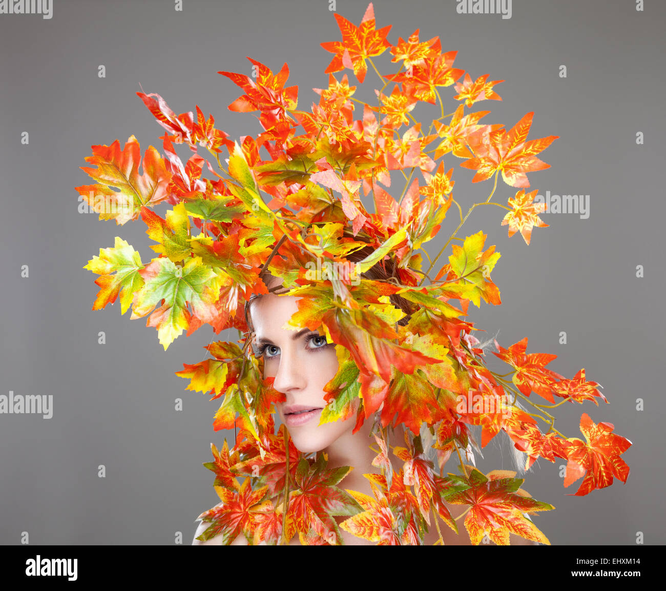 Woman wrapped up in autumn leaves Stock Photo - Alamy
