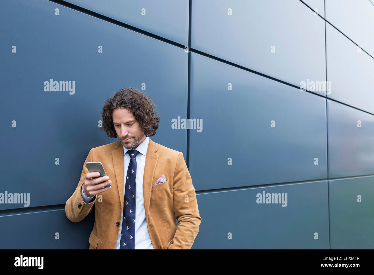 Man business suit cell phone reading SMS Stock Photo - Alamy