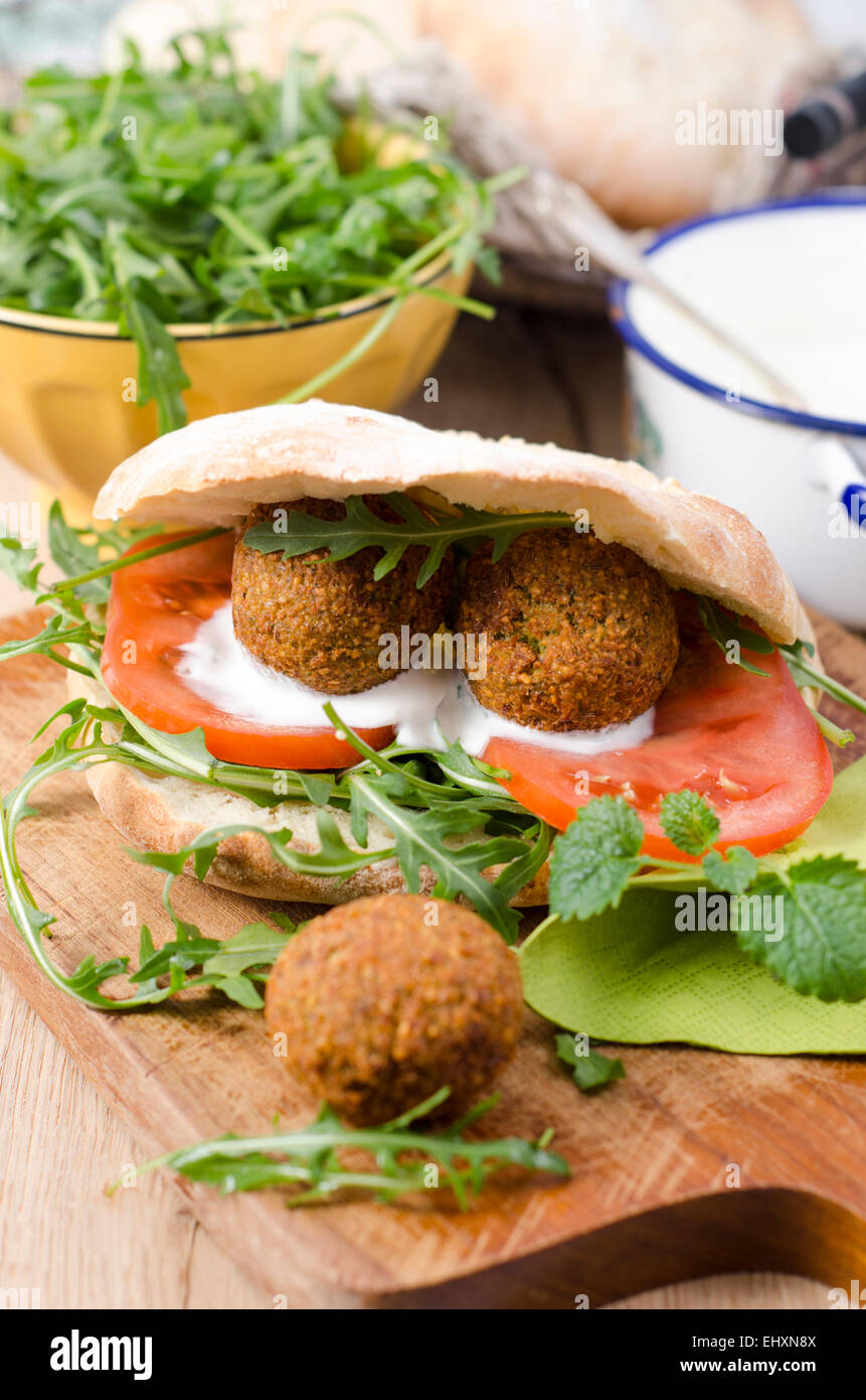 Homemade falafel, tomato, yoghurt sauce, rocket and mint in pita bread ...