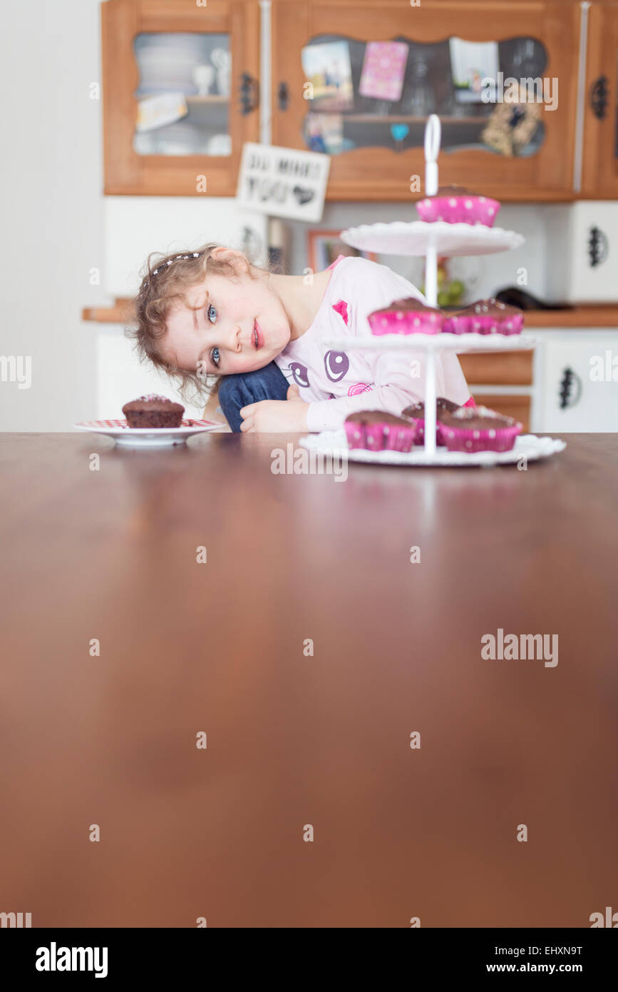 Little girl sitting at dining table Stock Photo - Alamy