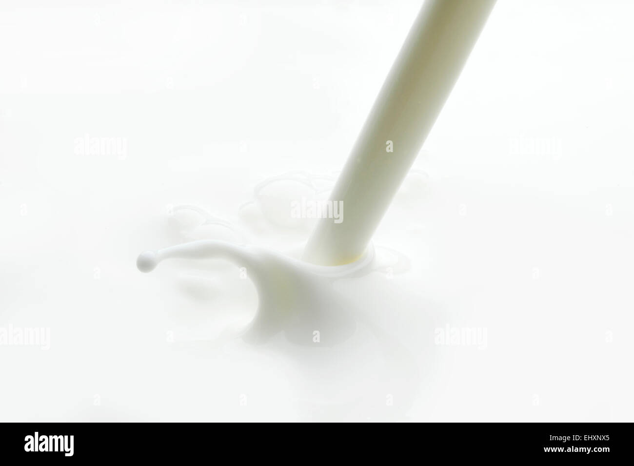 Pouring milk splash isolated on white background Stock Photo - Alamy