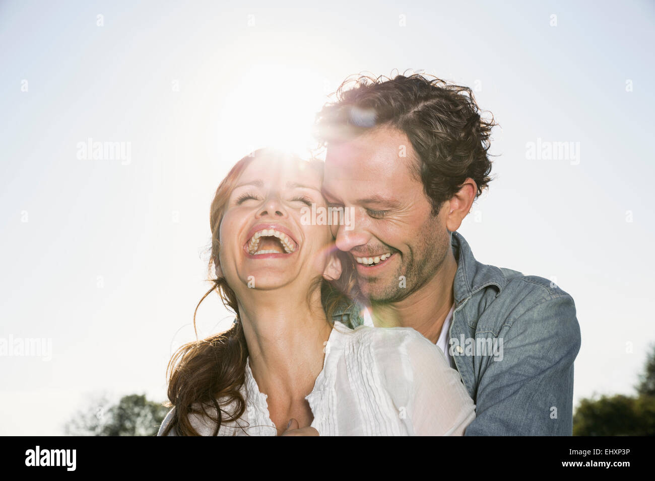 Laughing couple at backlight Stock Photo - Alamy