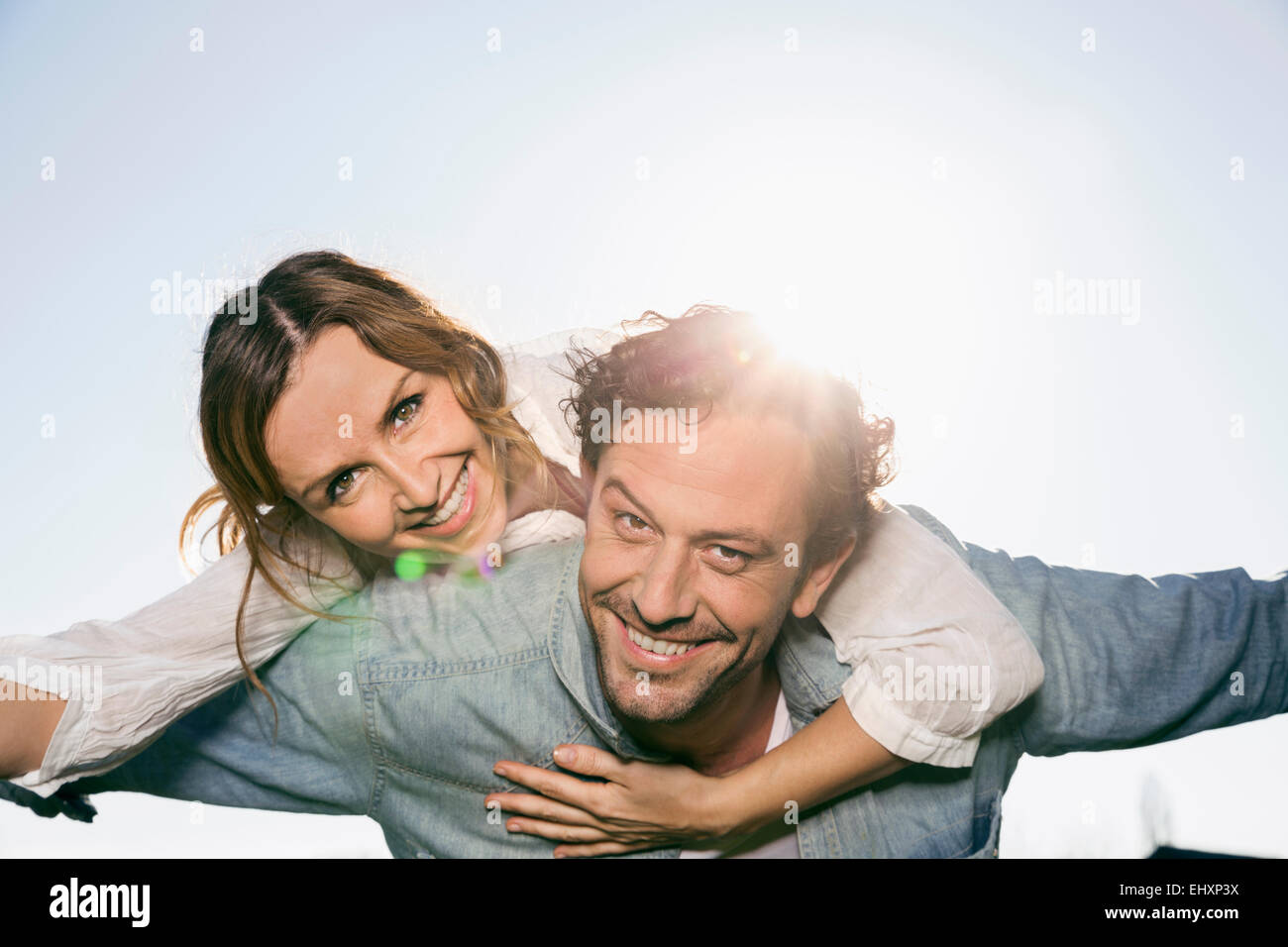 Happy couple with outstretched arms at backlight Stock Photo - Alamy