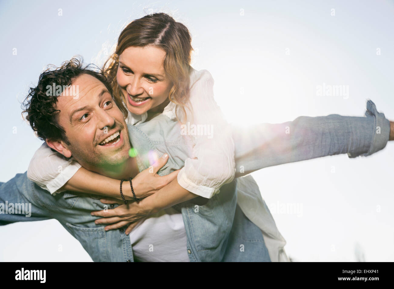 Man giving woman a piggy back Stock Photo - Alamy