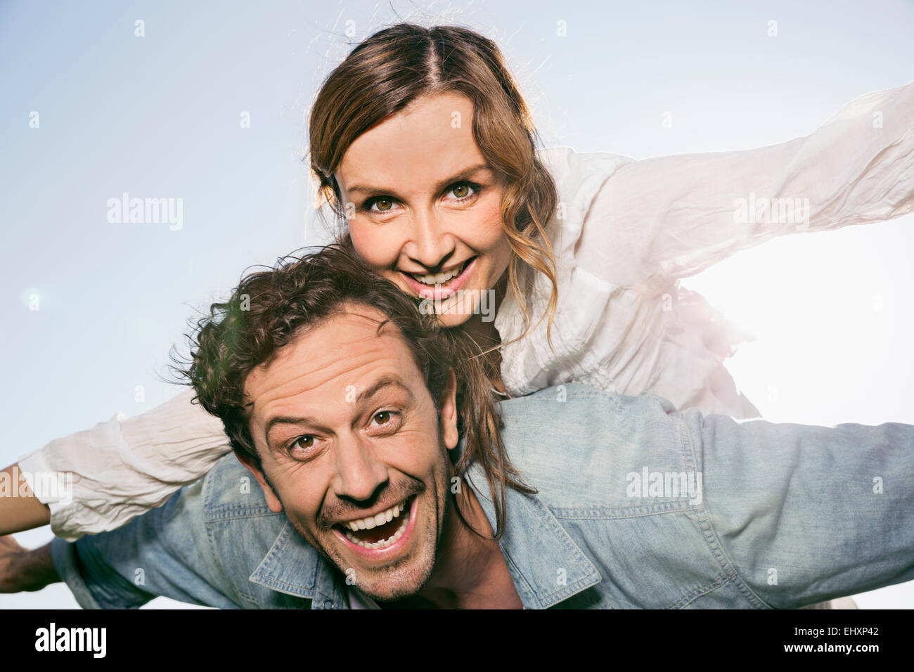 Happy couple with outstretched arms at backlight Stock Photo - Alamy