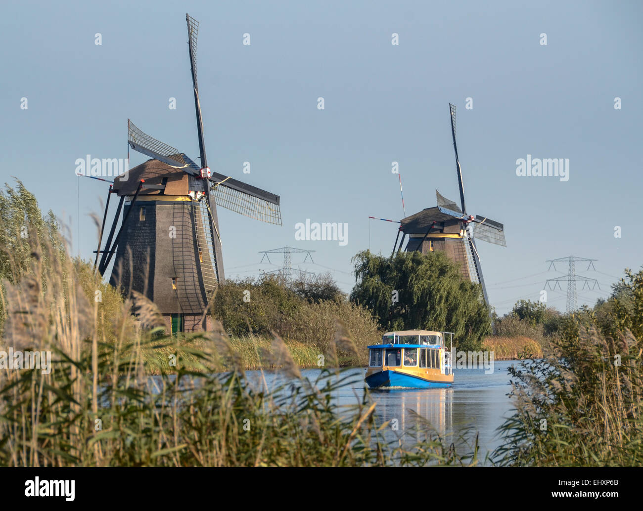 Windmills at Kinderdijk in the Netherlands with a boat which takes ...