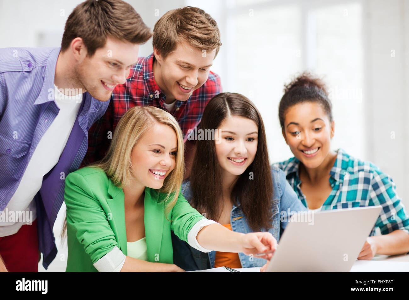 smiling students looking at laptop at school Stock Photo - Alamy